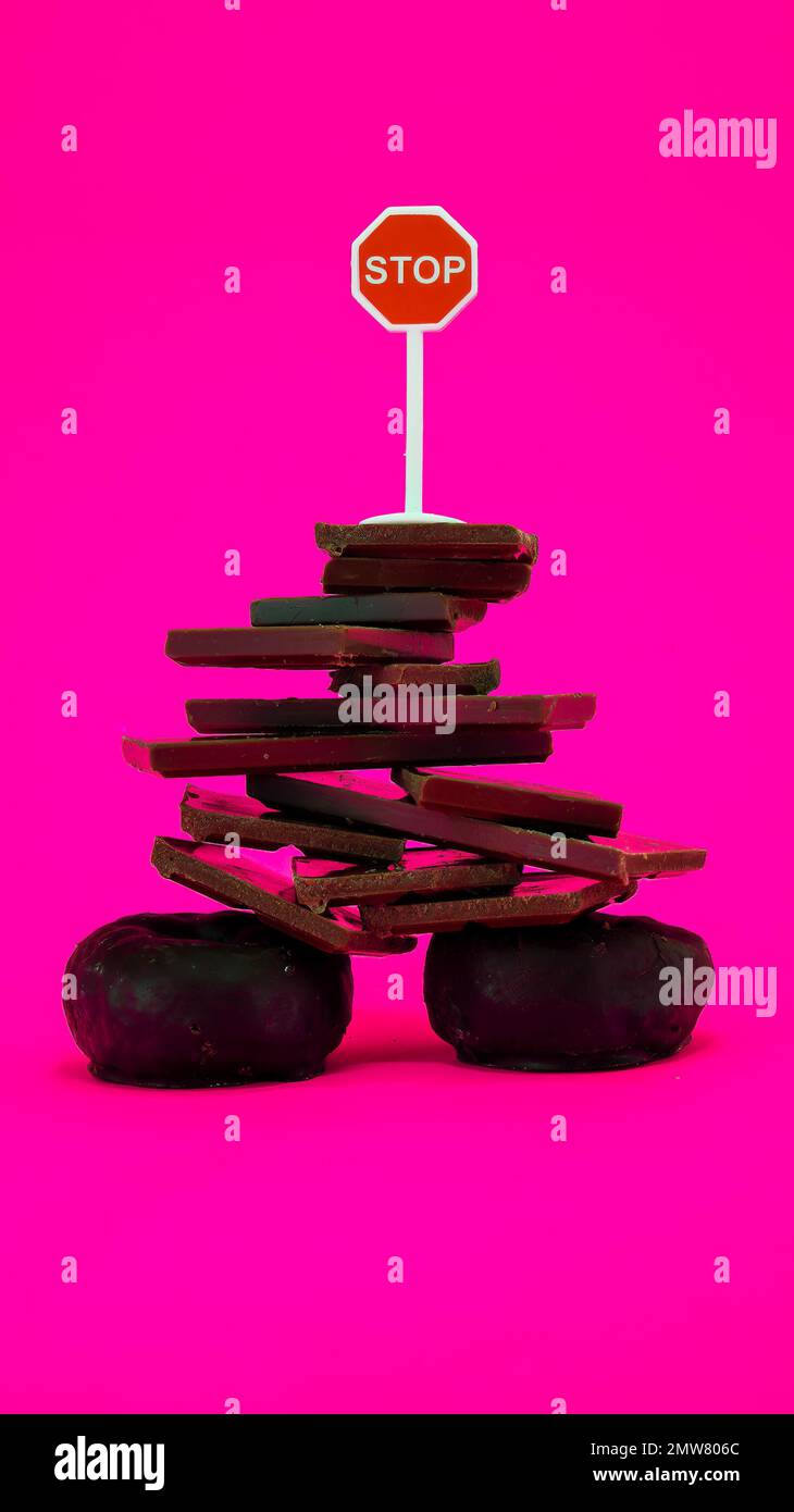 Chocolate and donuts isolated on pink background with stop sign on top ...