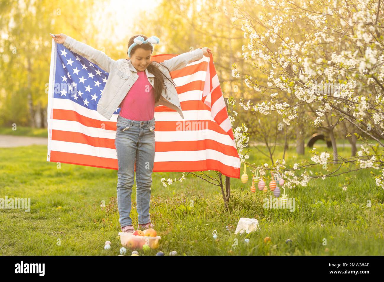 Girl kid in rabbit bunny ears on head with colored eggs and american ...
