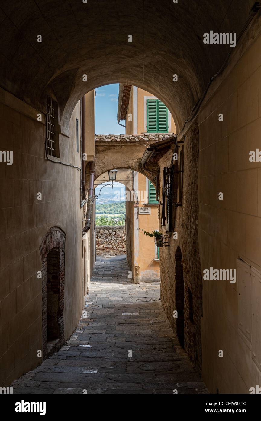 A vertical shot of a narrow road through the arches of the buildings in ...