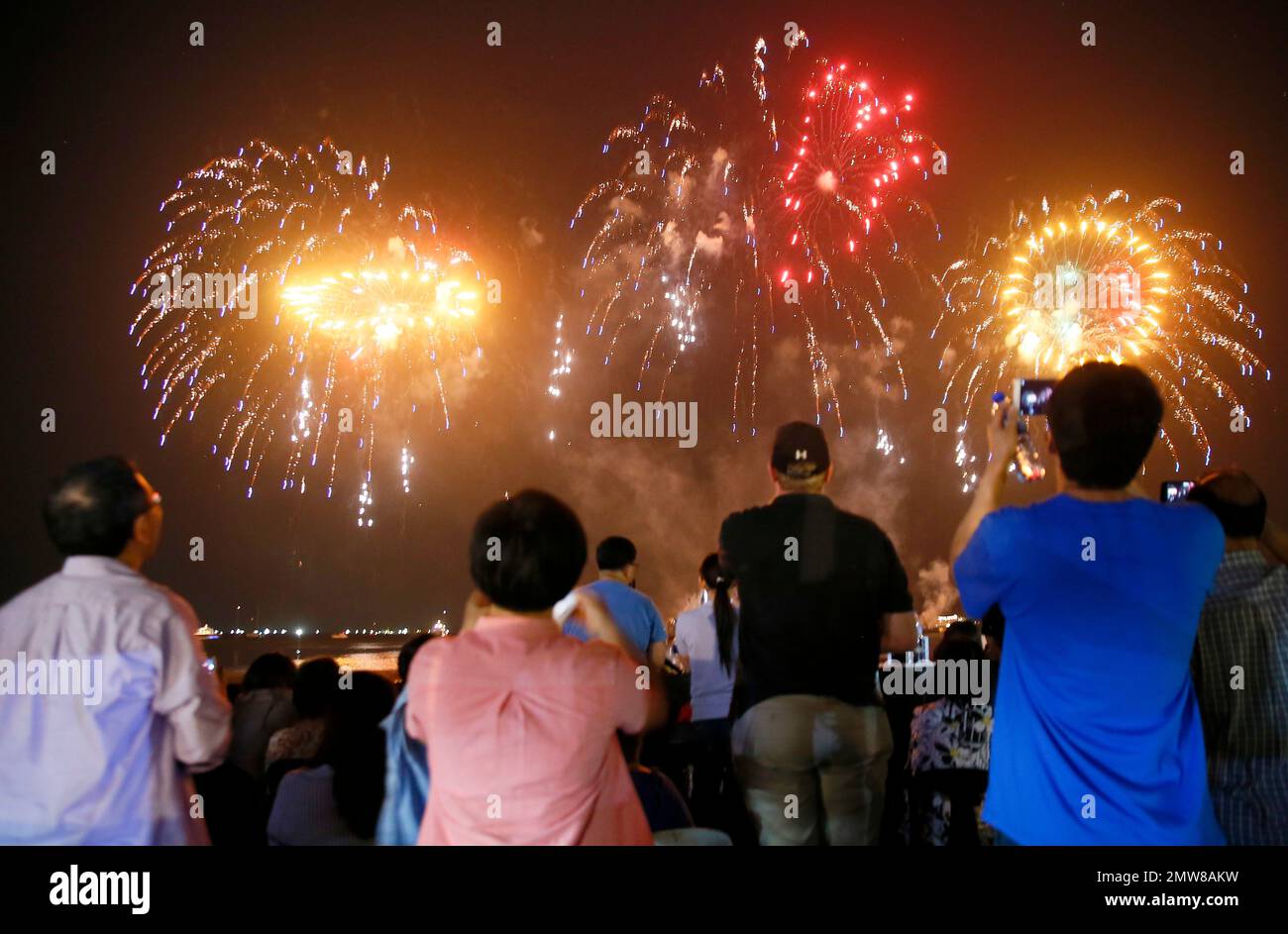 Tourists watch as fireworks from the Philippines' Platinum fireworks ...