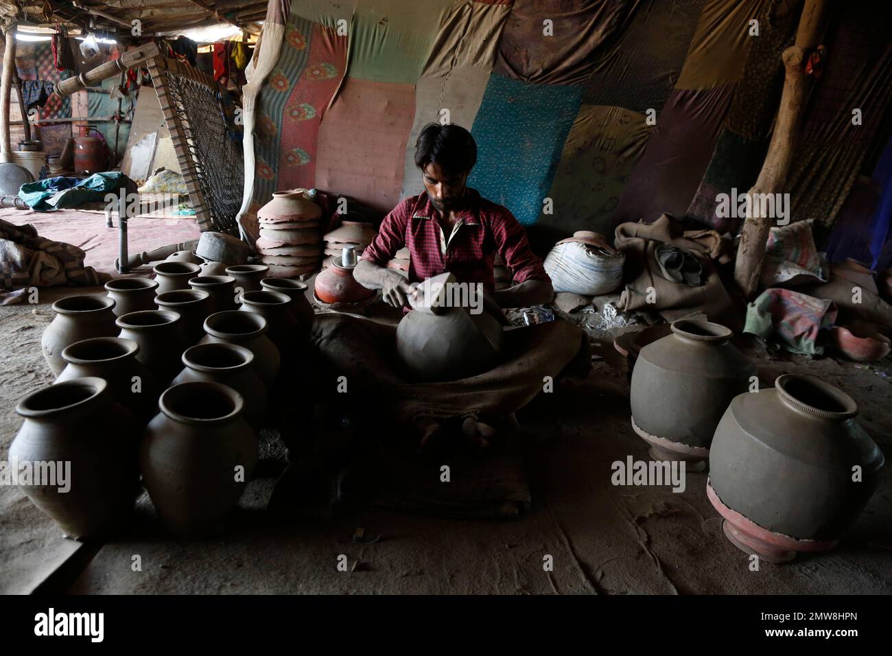 An Indian potter makes earthen pots at his house on the outskirts of ...