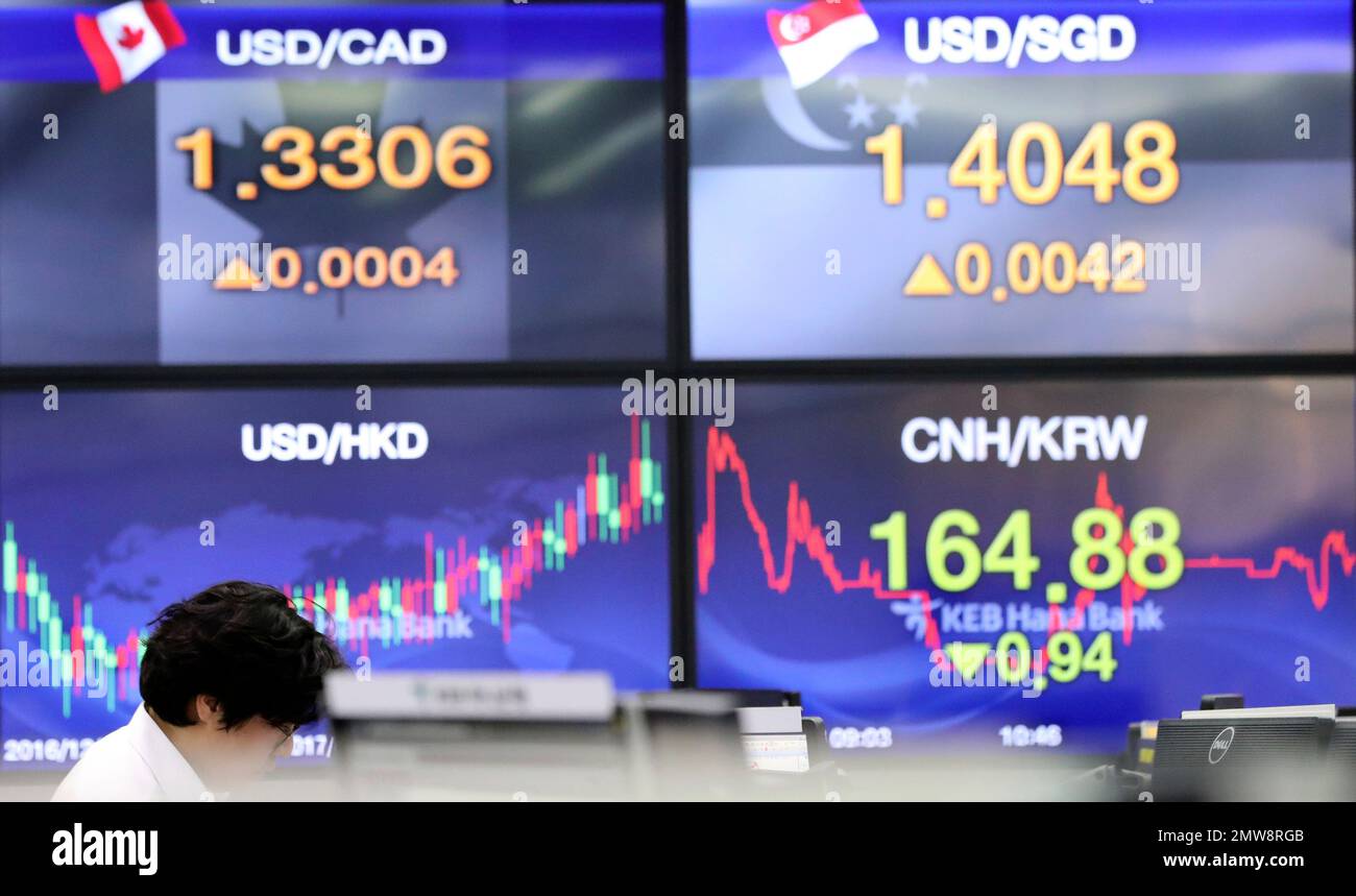 A currency trader watches monitors near the screens showing the foreign ...