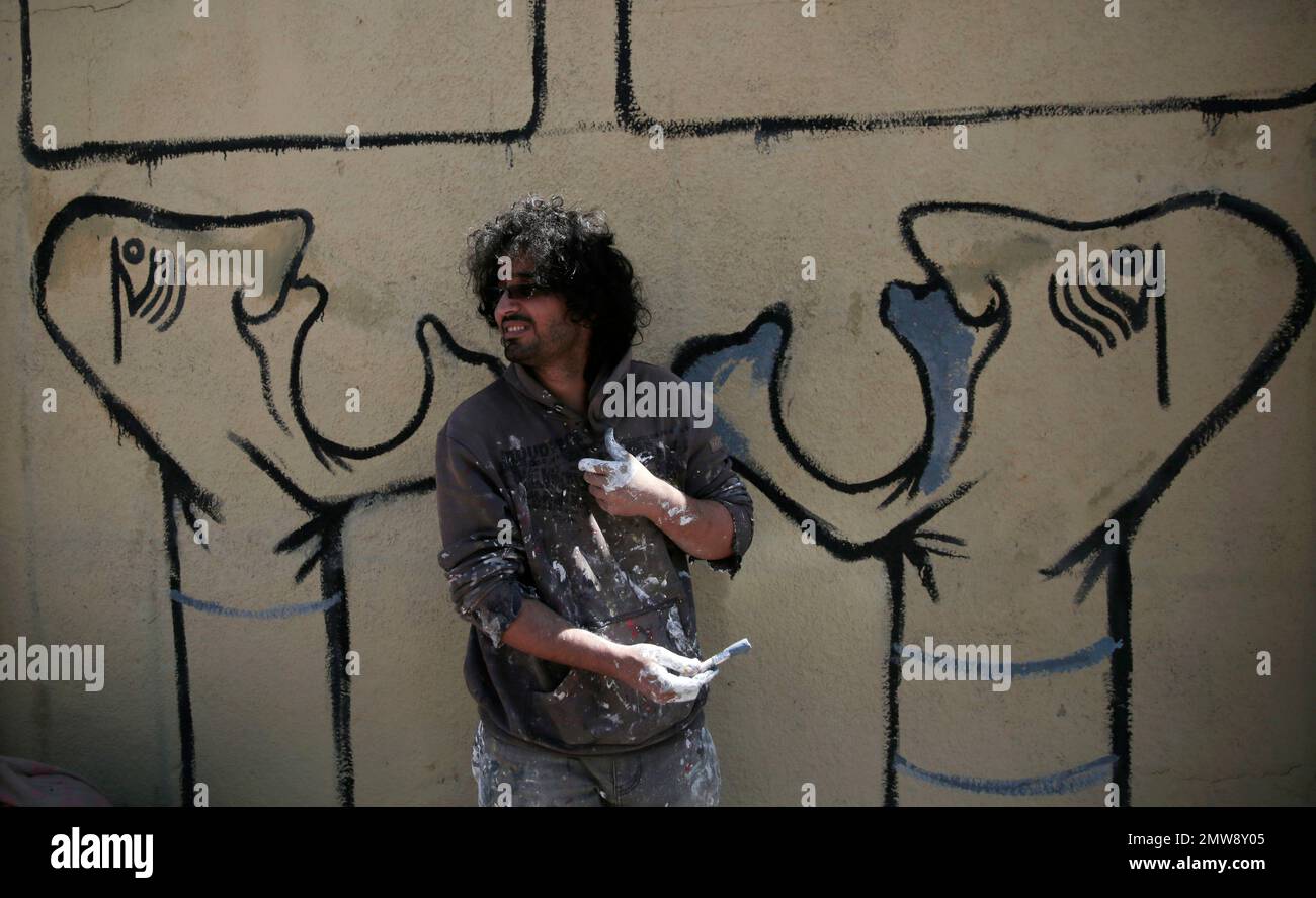 Yemen artist and activist Murad Subay paints graffiti on a wall during ...