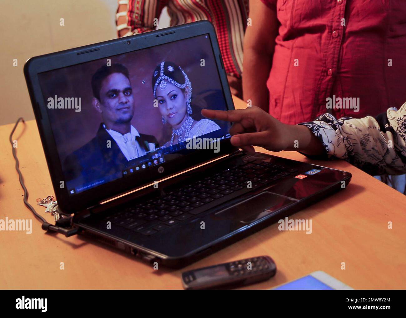 Sister Namalee Makalandawa, shows a wedding photograph of Premnath ...