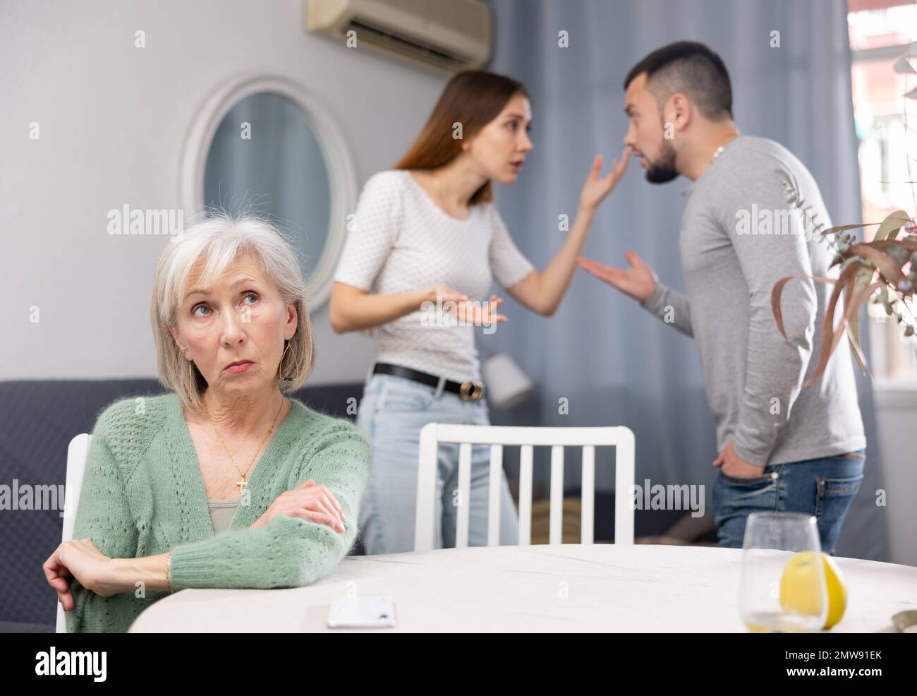 Old woman ignoring her daughter and son-in-law arguing with each other ...