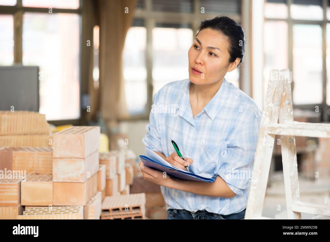 Woman checks the completed construction work on drawing Stock Photo - Alamy