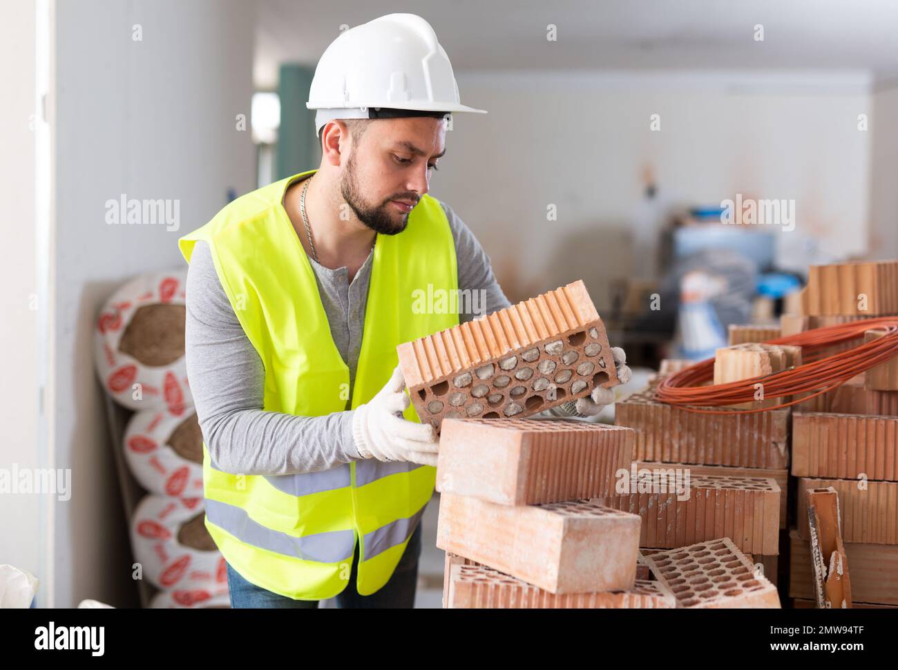 Construction worker checking bricks at renovating object Stock Photo ...