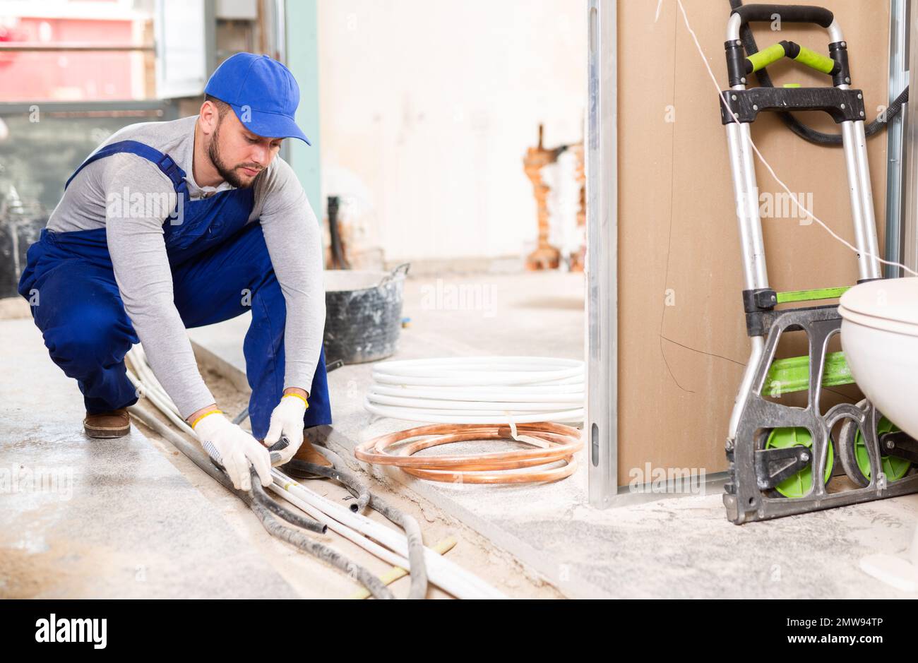 Man electrical installer laying cables through trench Stock Photo - Alamy