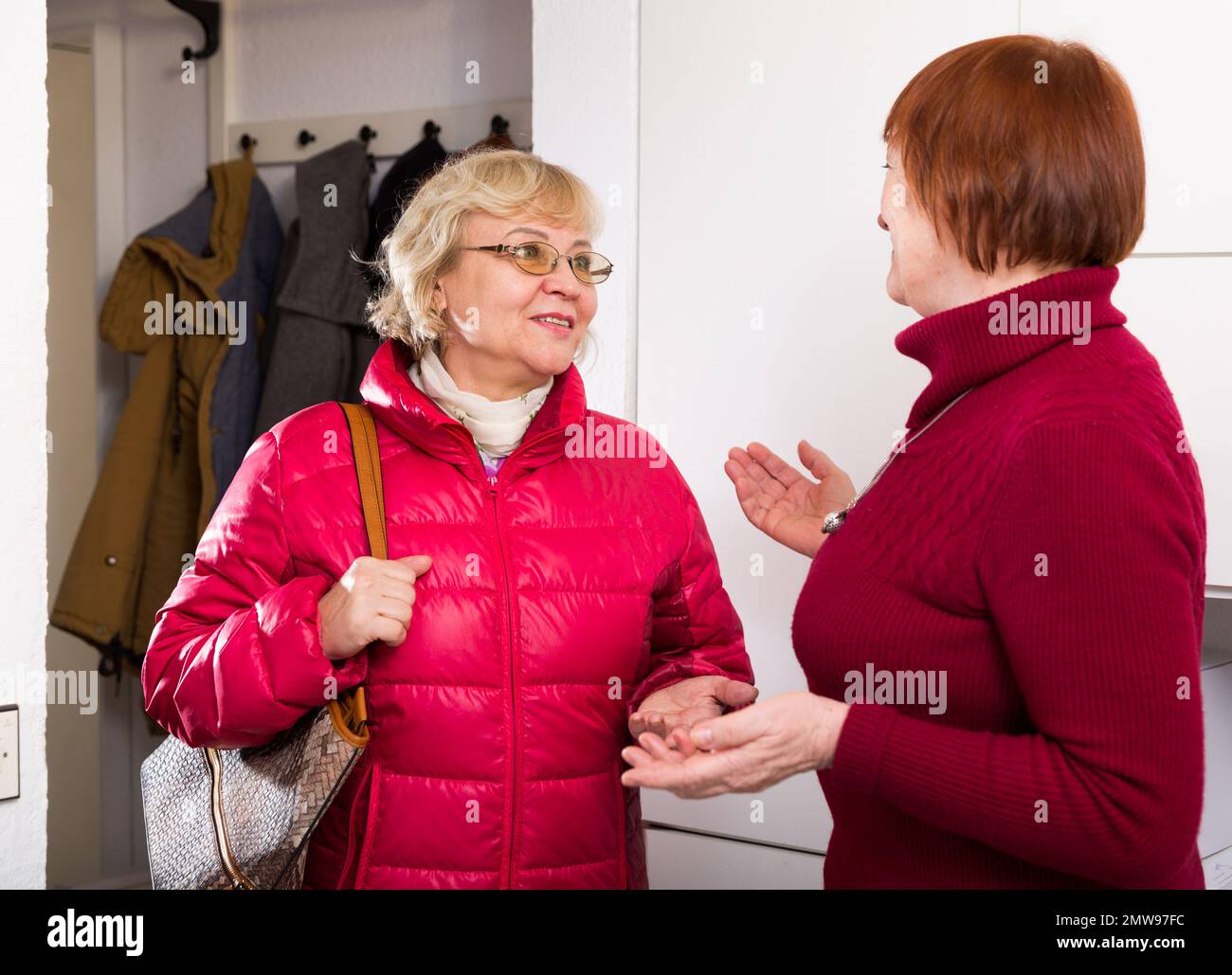 Senior woman welcoming female friend Stock Photo - Alamy