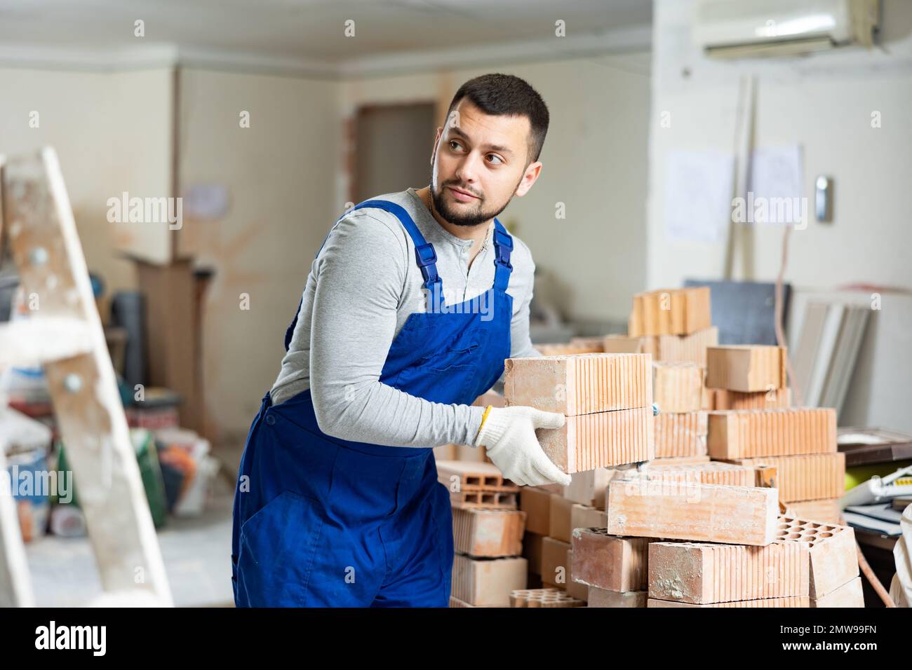 Construction worker carrying bricks at renovating object Stock Photo ...