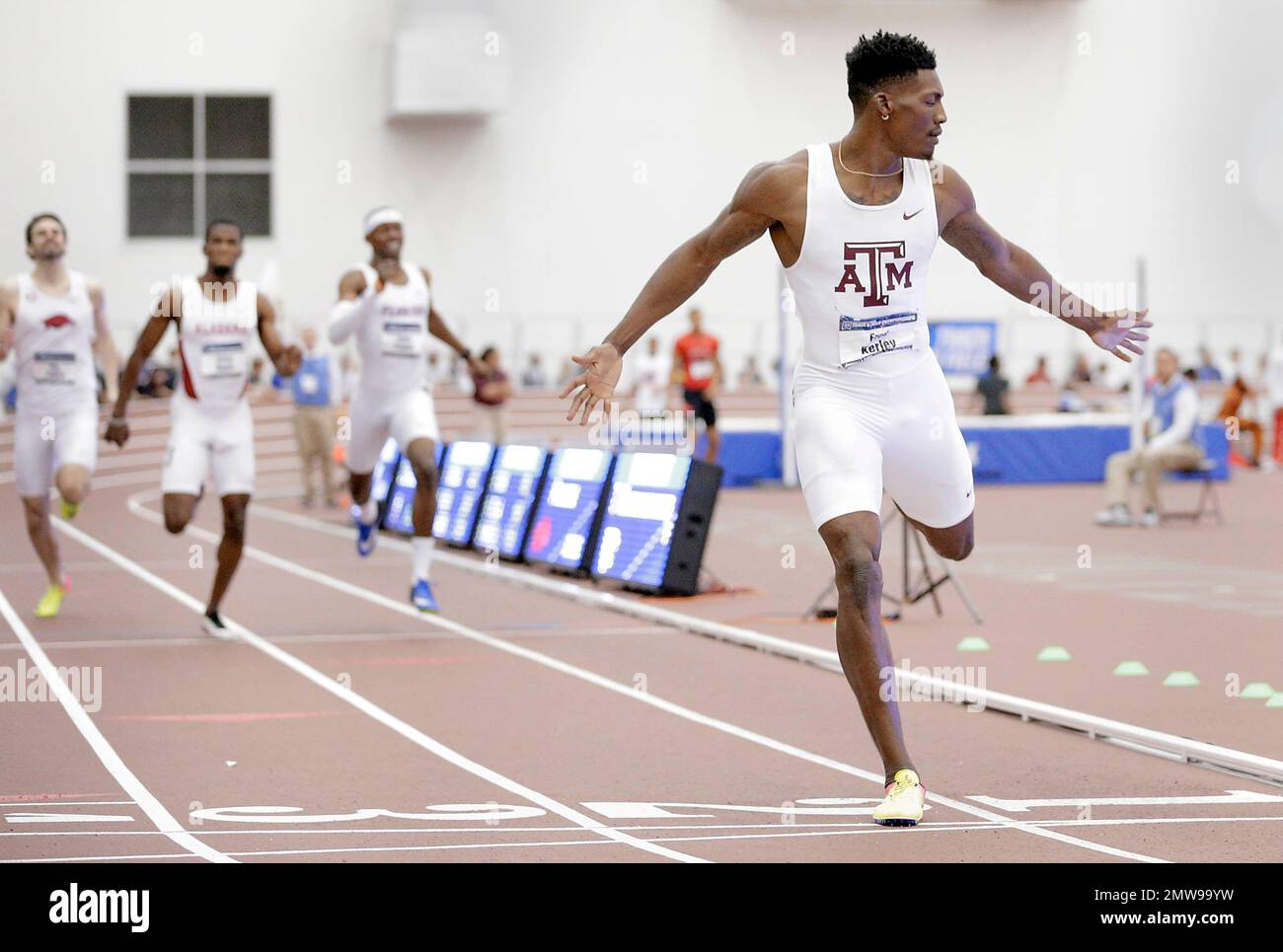 Texas A&M's Fred Kerley puts his arms out as he crosses the finish line ...