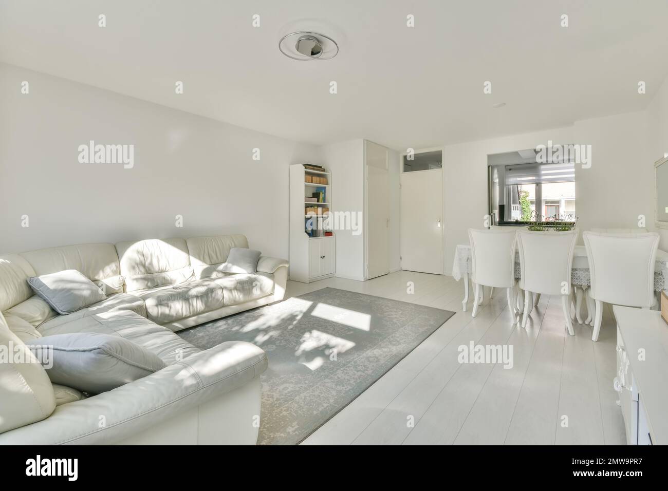 an empty living room with white furniture and large windows in the ...