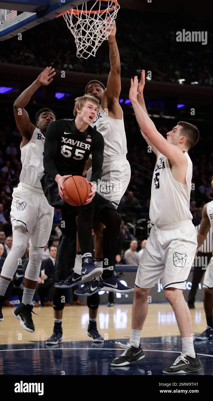 Xavier's J.P. Macura (55) is defended by Butler's Kelan Martin, left ...