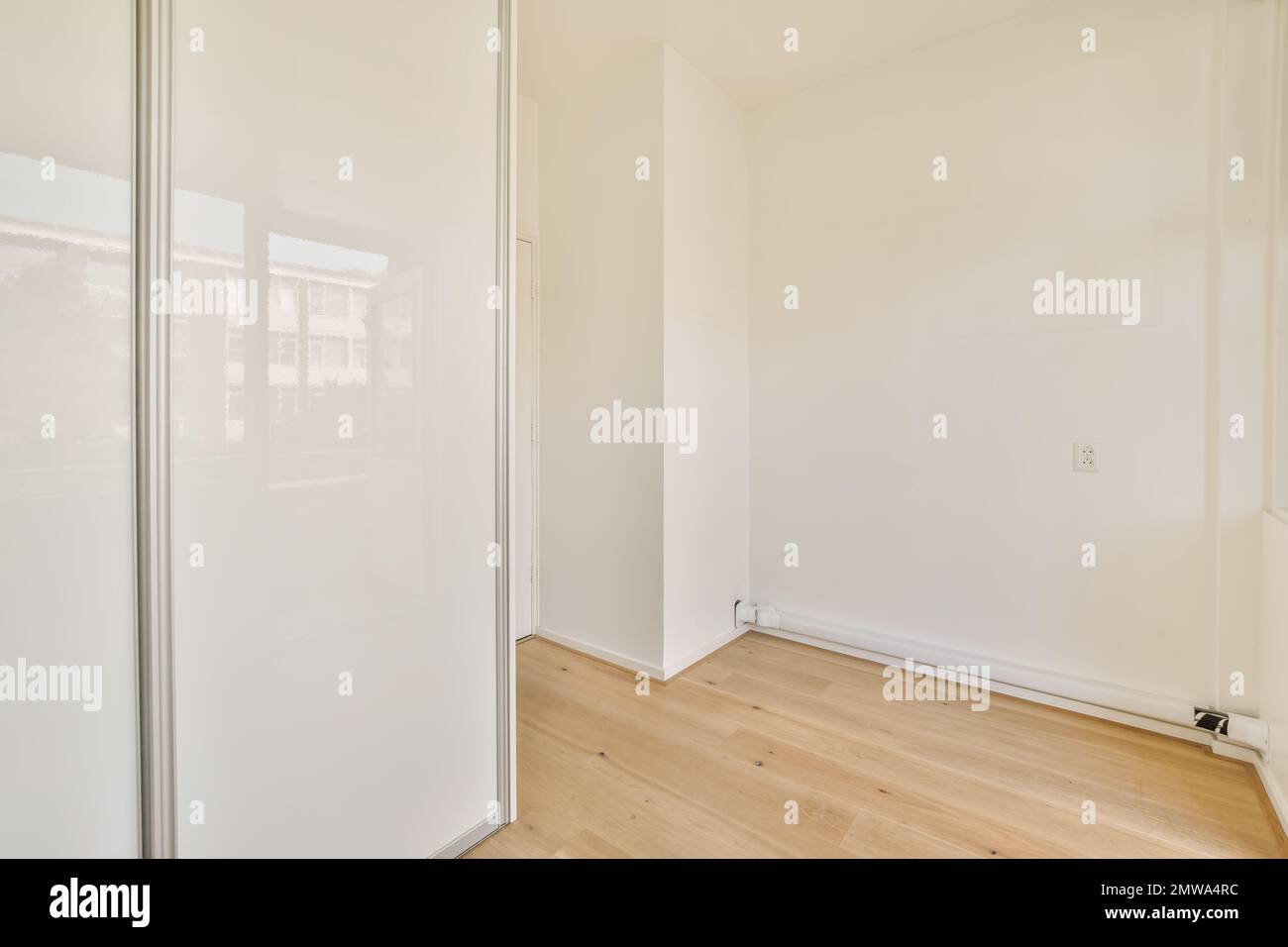 an empty room with white walls and wood flooring on the right side ...