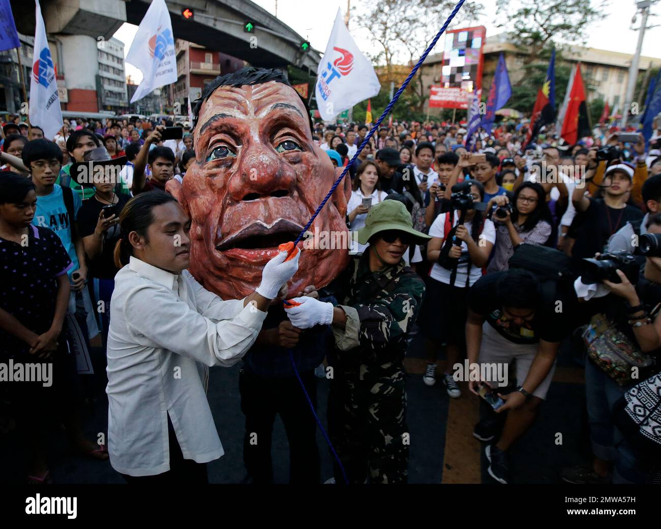 A protester wearing a big mask of Philippine President Rodrigo Duterte ...