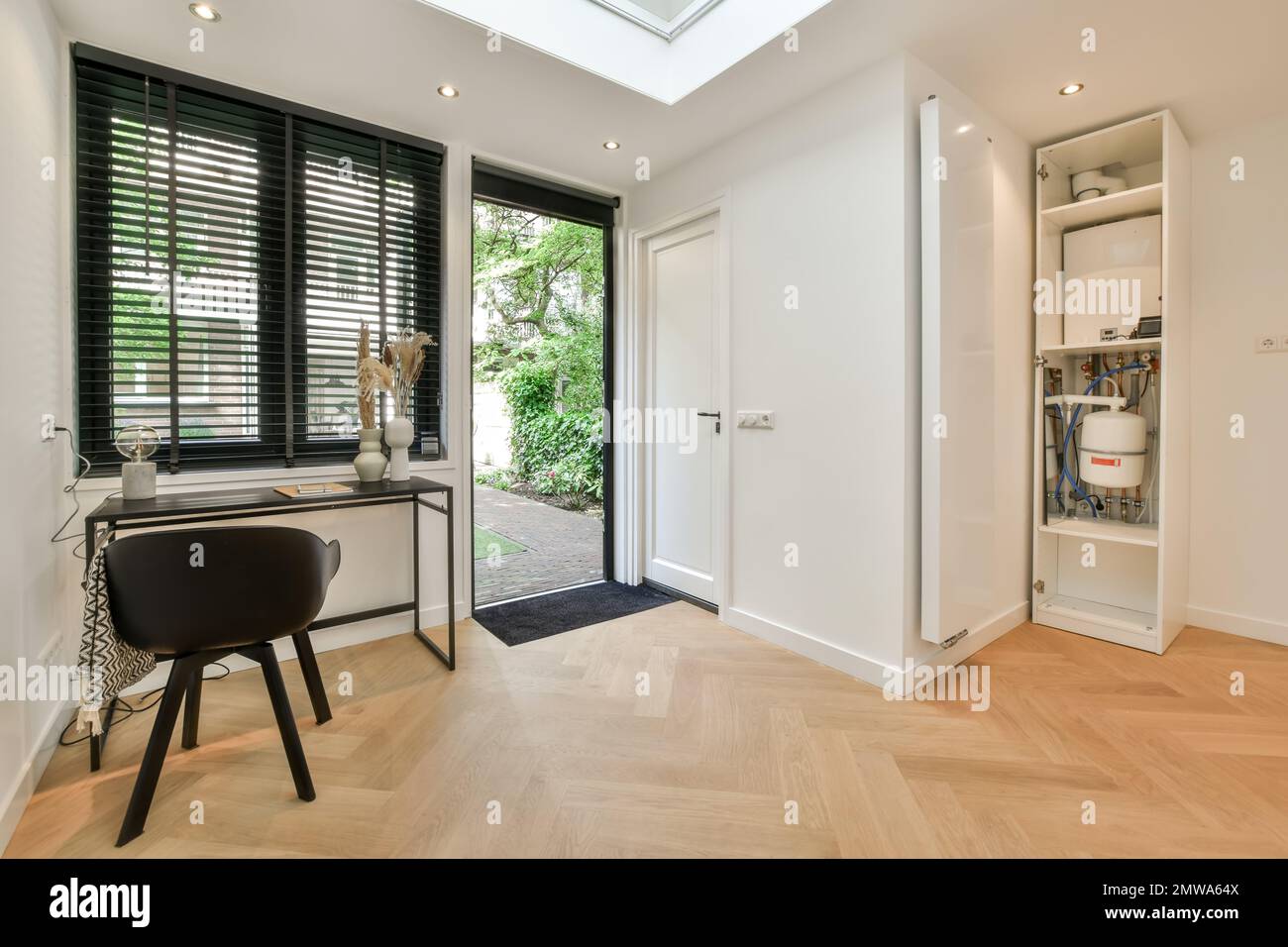 a home office with white walls and black shutters on the doors, wooden ...