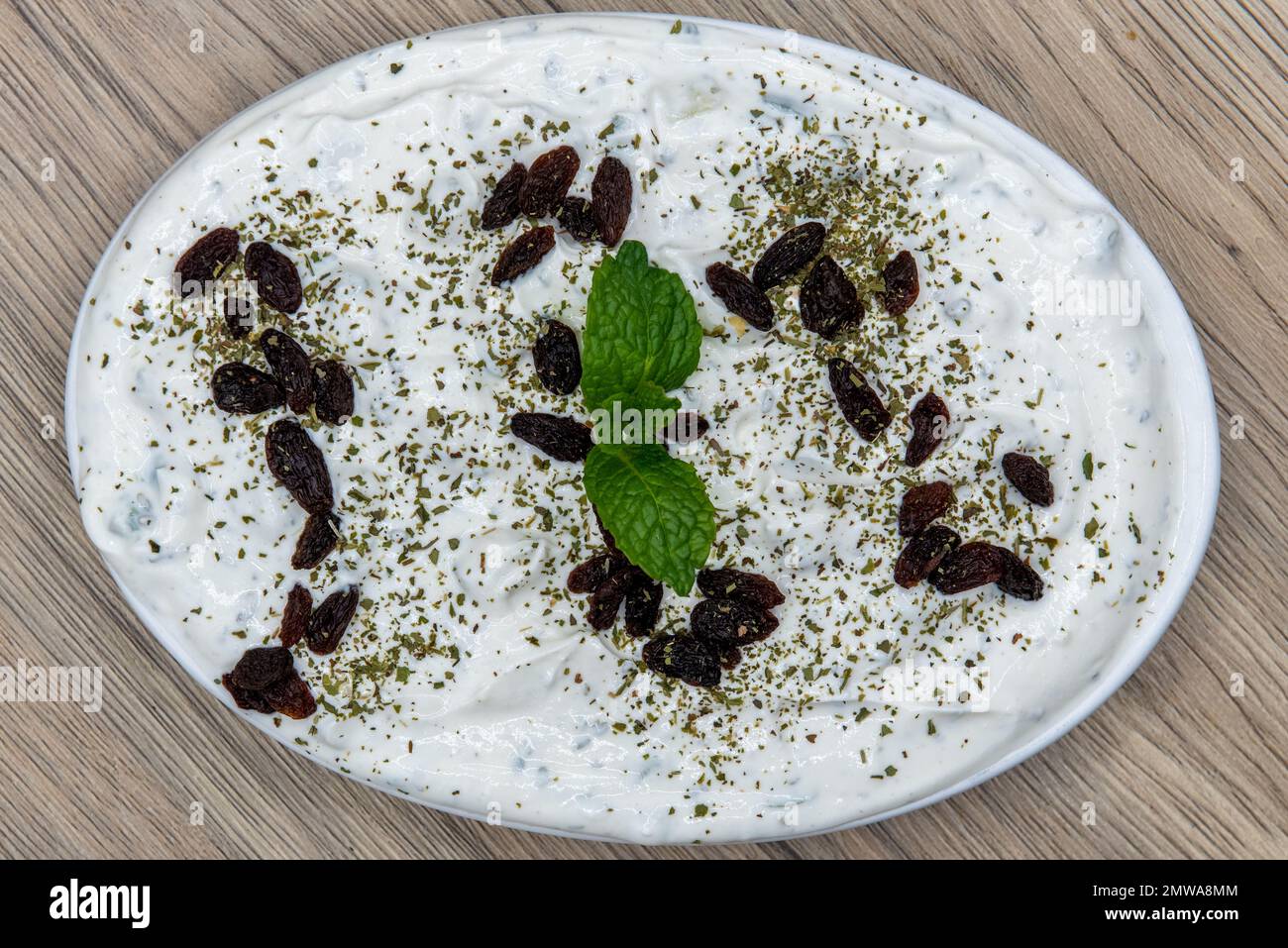 Overhead view of hearty plate of maust khiar yogurt appetizer topped ...