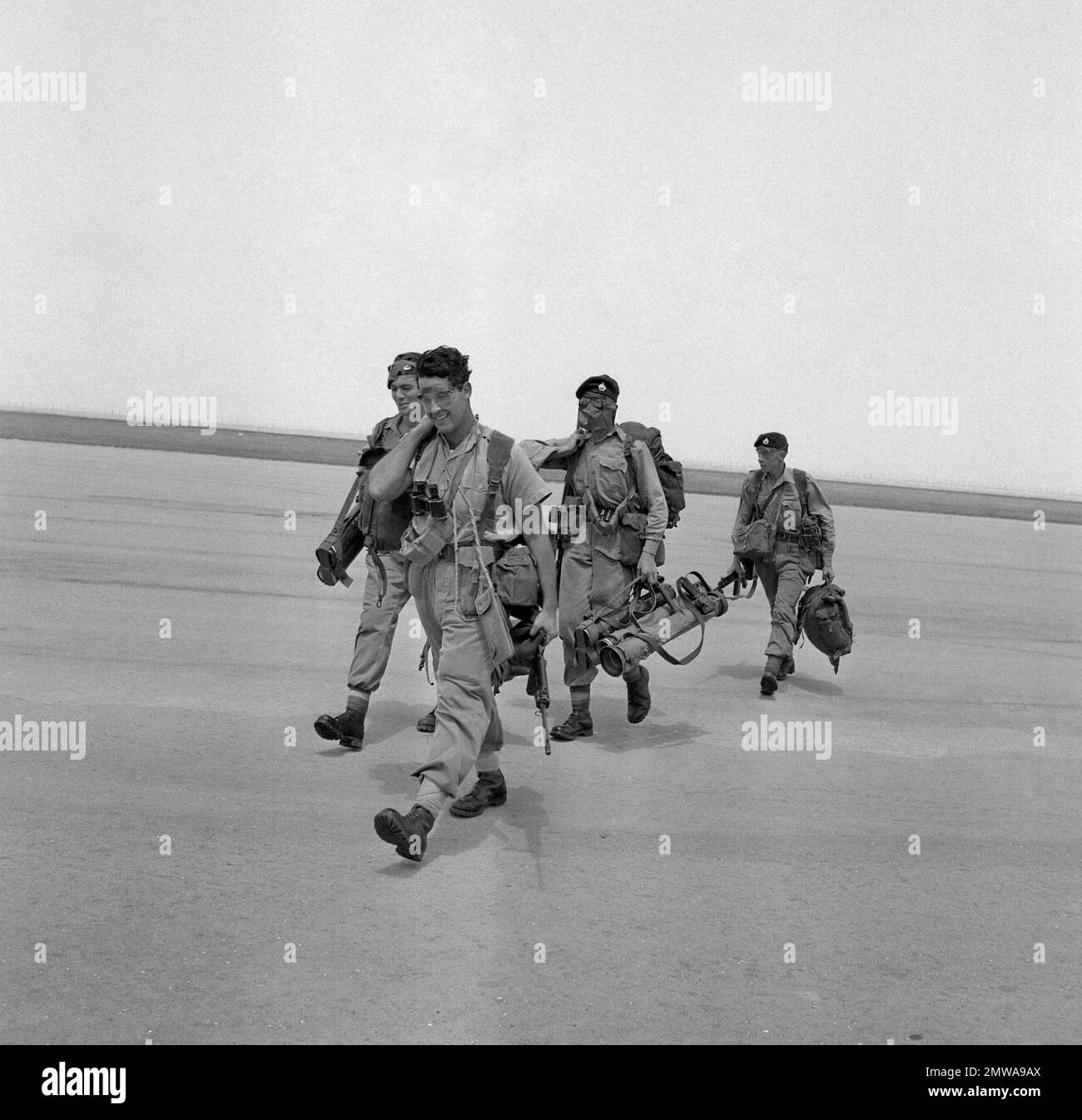 Men of the Royal Marine Commandos carry equipment across the Farwaniya ...