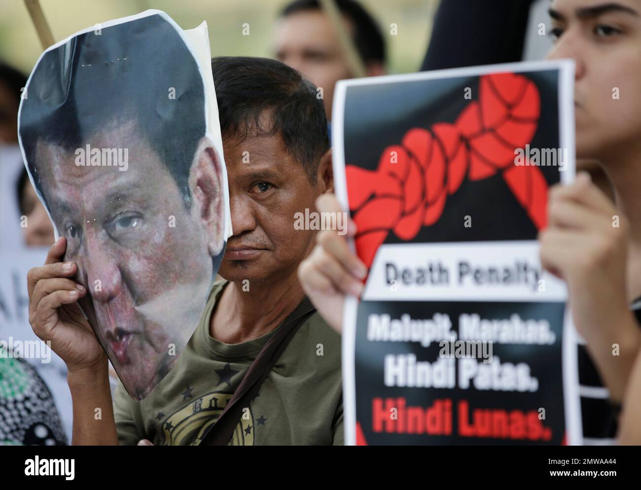 A protester holds a mask of Philippine President Rodrigo Duterte during ...