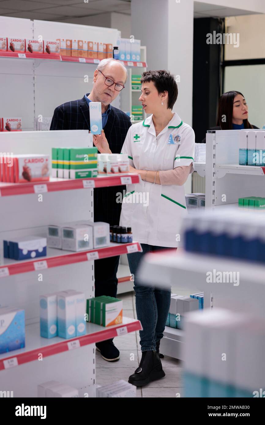 Pharmaceutical specialist holding sunscreen box and reading instruction ...
