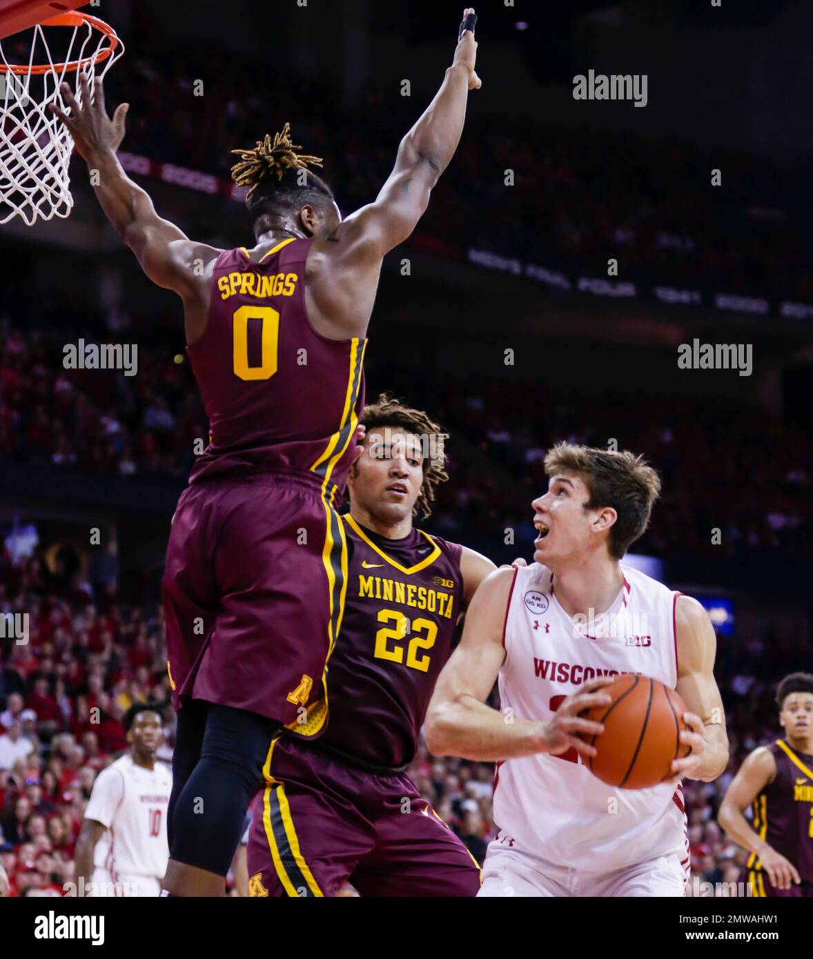 Wisconsin's Ethan Happ (22) goes up against Minnesota's Akeem Springs ...