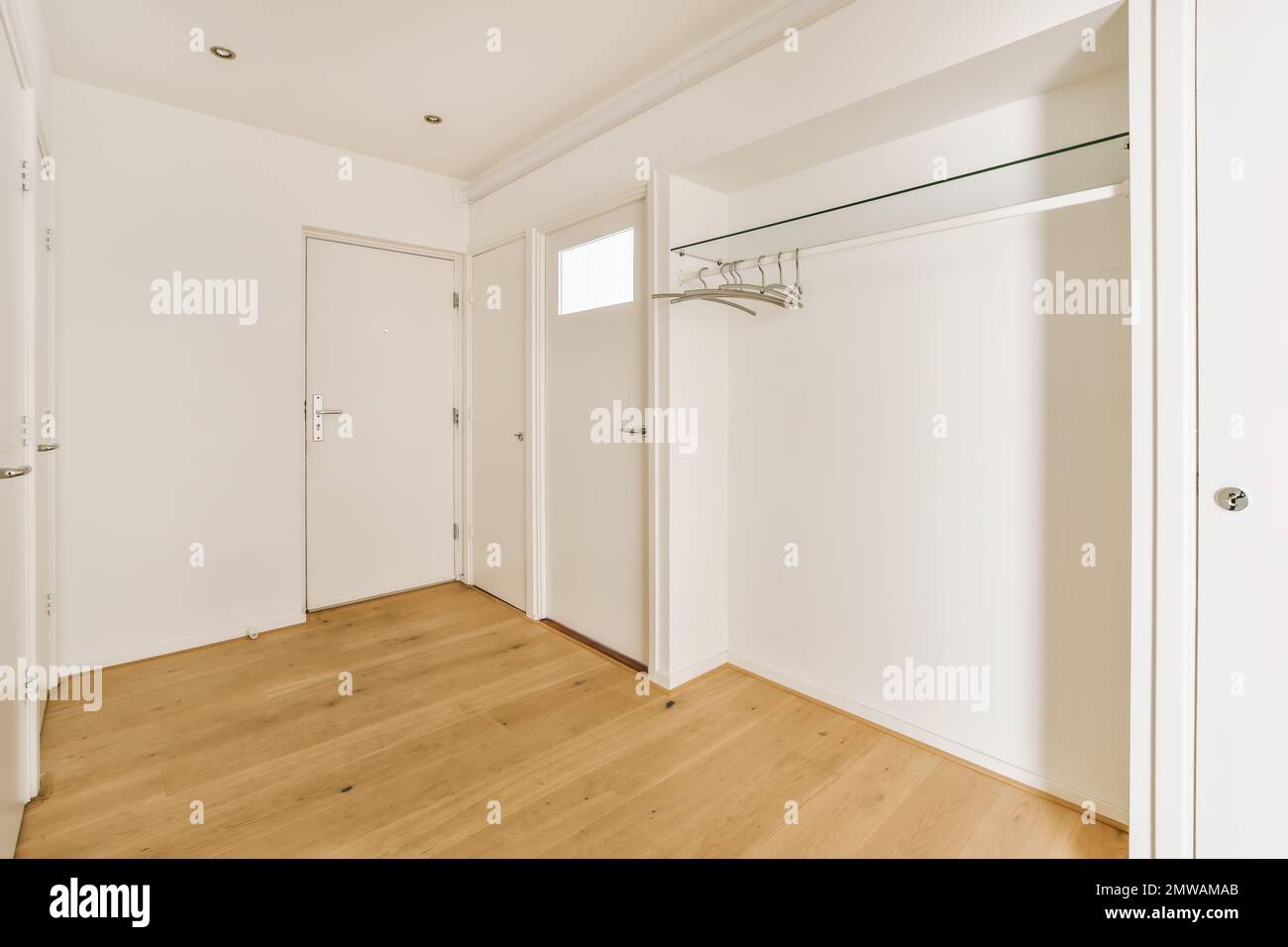 an empty room with white walls and wood flooring on the left, there is ...