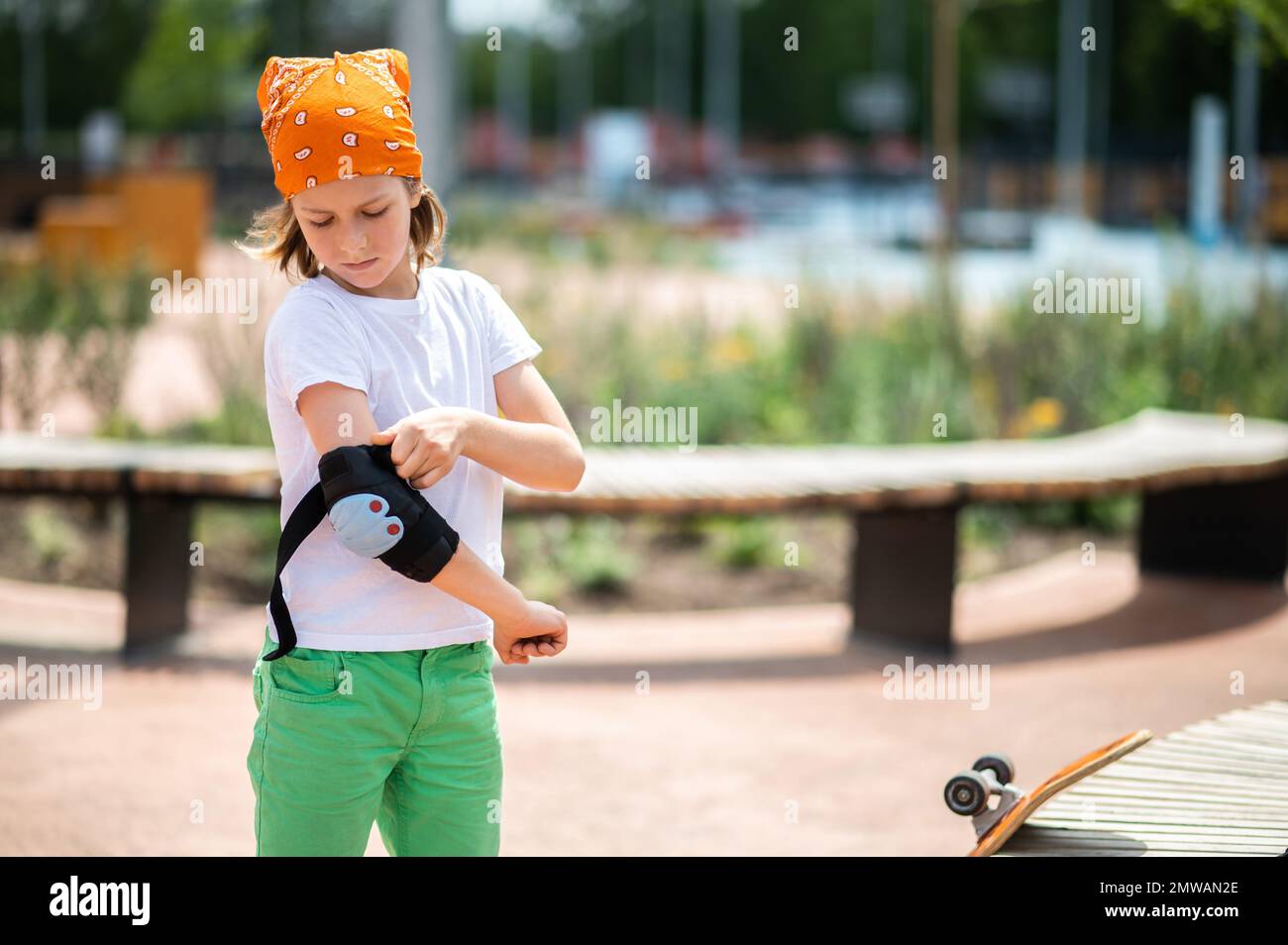 Kid putting on the protective gear before skateboarding Stock Photo - Alamy