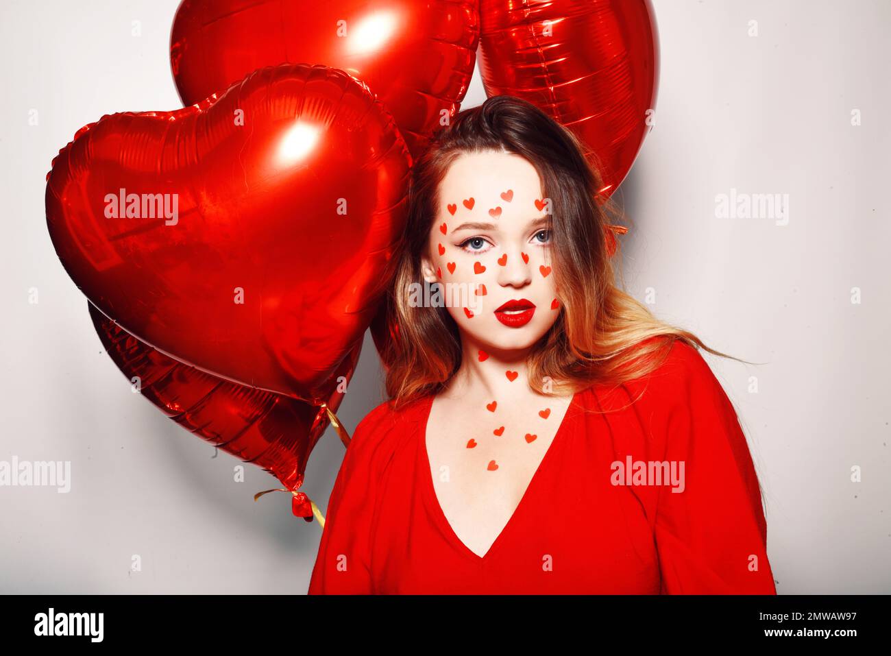 Beautiful woman with heart stickers on her face. Girl on a white ...