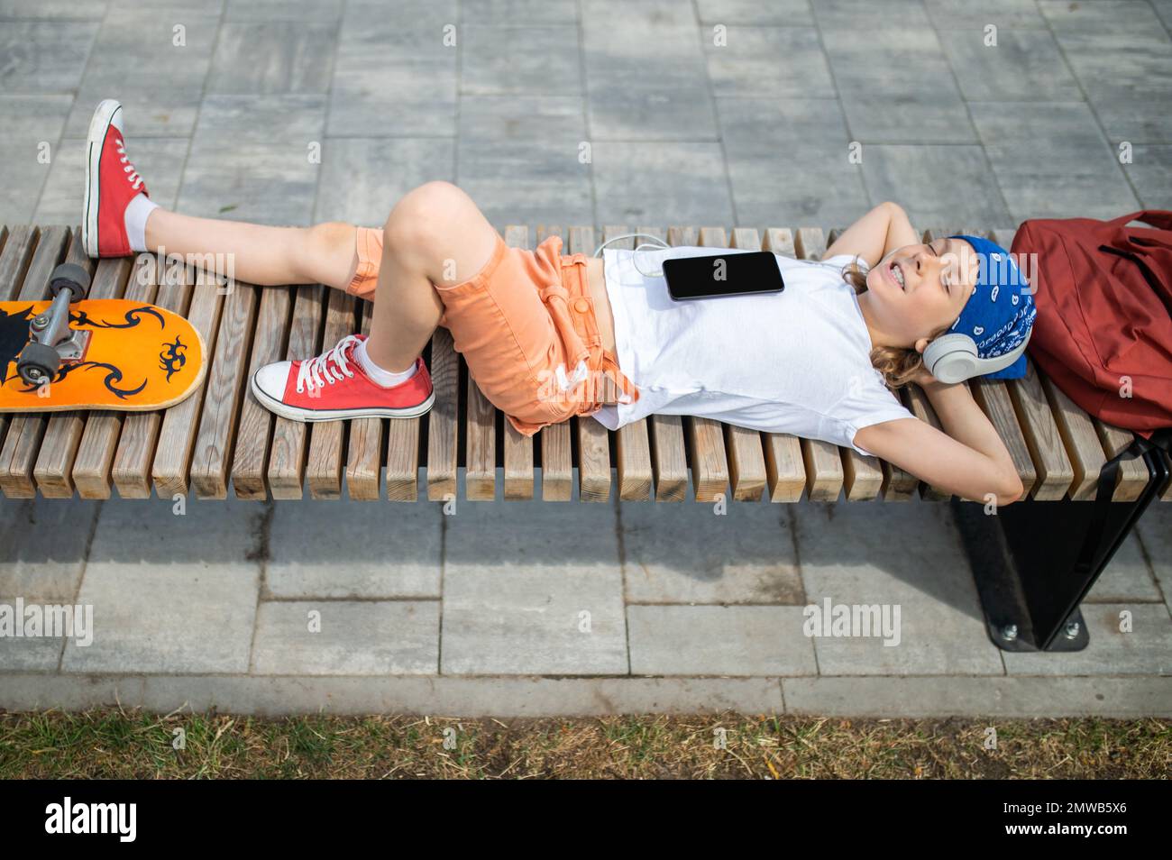 Pleased kid resting on the bench outdoors Stock Photo - Alamy