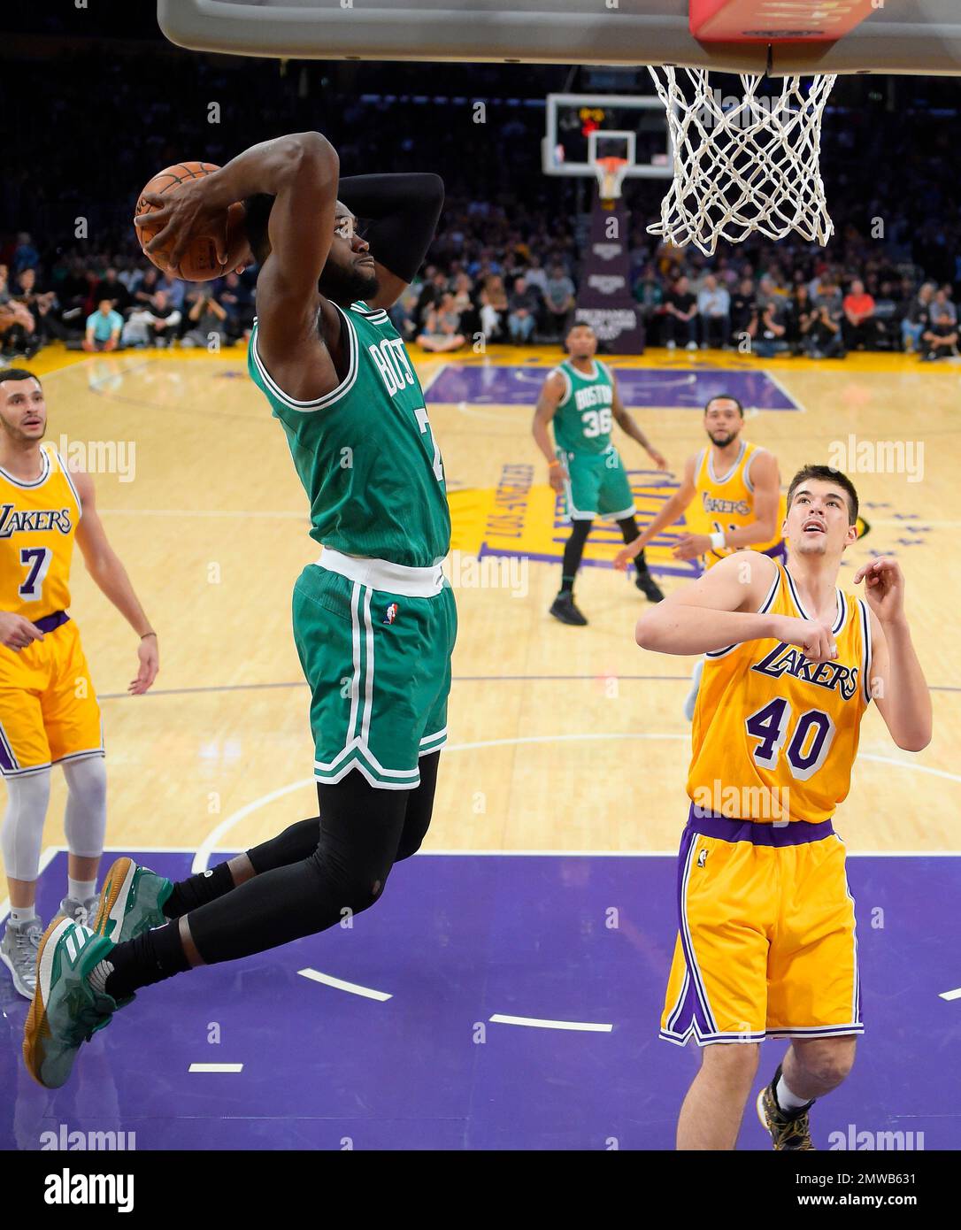 Boston Celtics forward Jaylen Brown, left, goes up for a dunk as Los ...