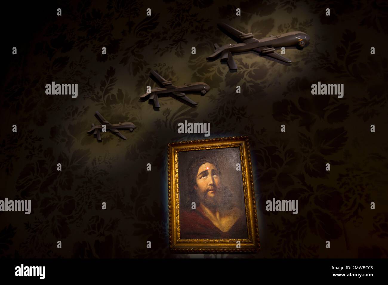 A wall decorated with models of drones and a painting of Jesus with a ...