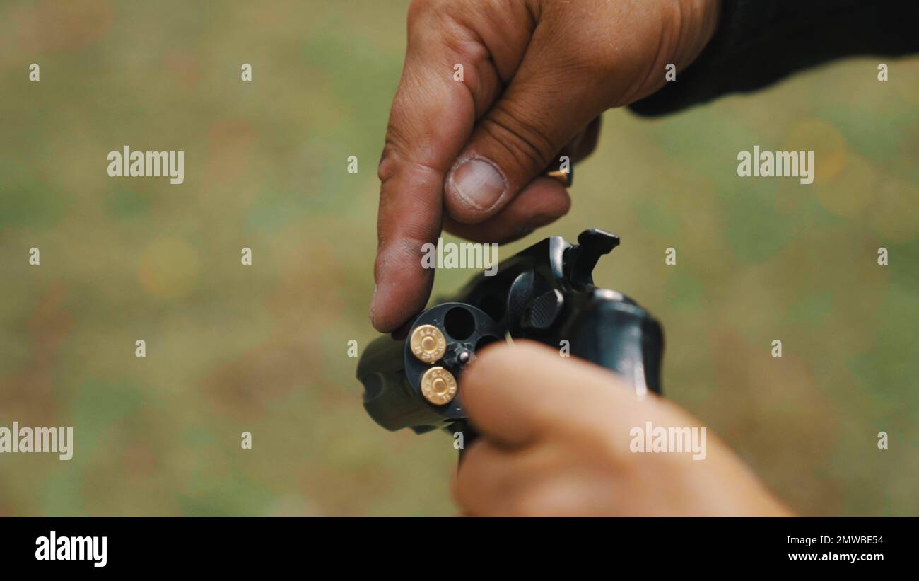 The correct way to load a gun with ammunition . Putting the bullet in ...