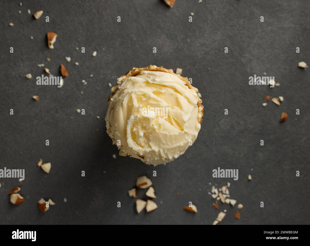 vanilla ice cream ball in waffle cone on dark grey table background ...