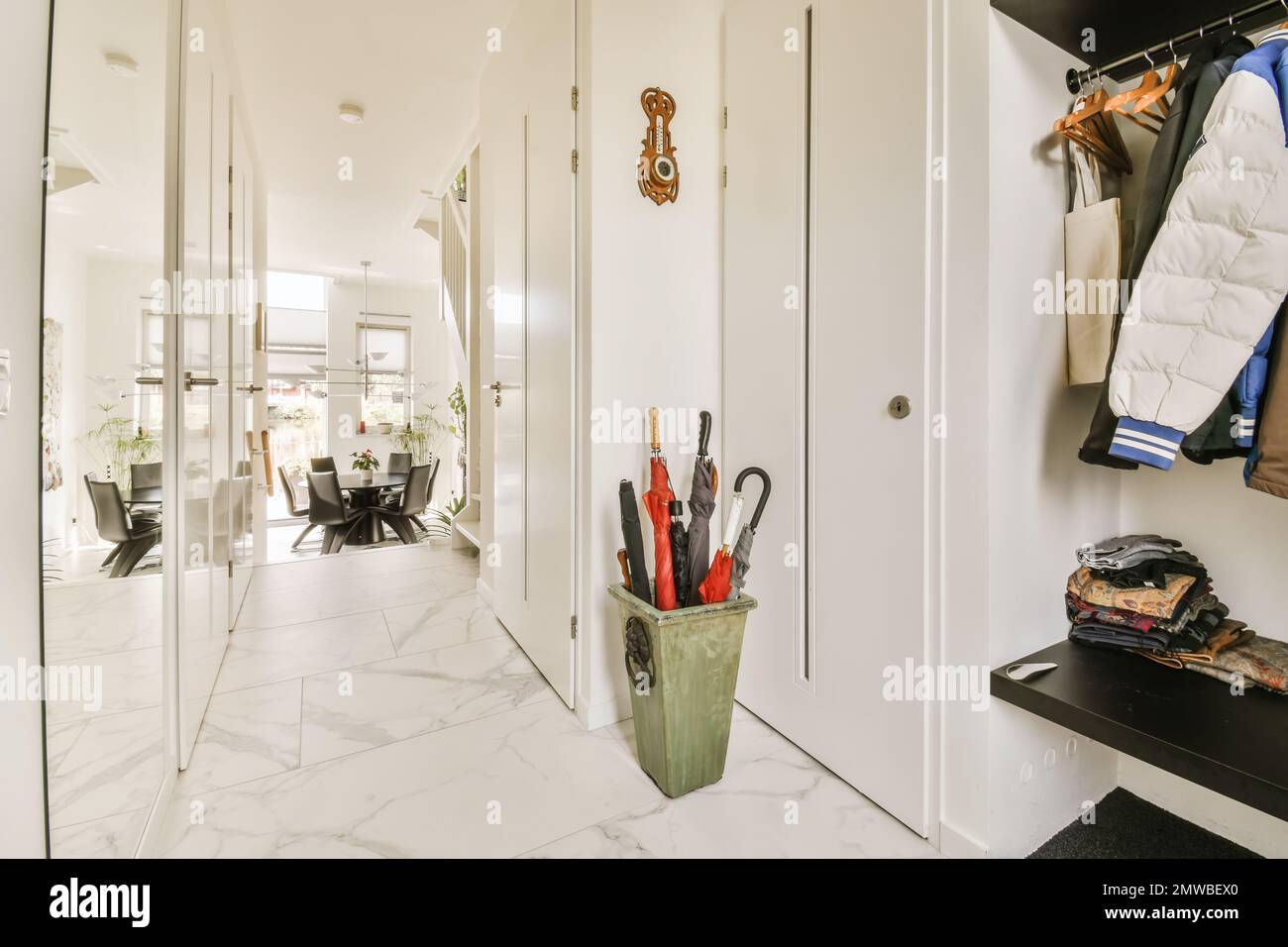 a walk - in closet with clothes hanging on the wall and an open door ...