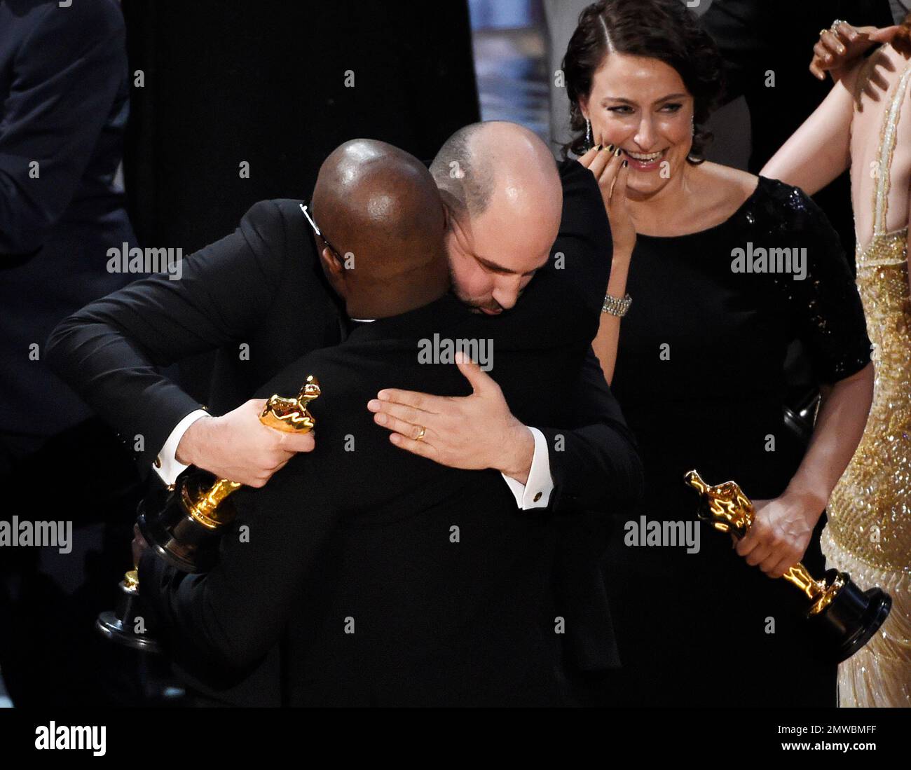 "La La Land" producer Jordan Horowitz, second from left, hugs "Moonlight" director Barry Jenkins ...