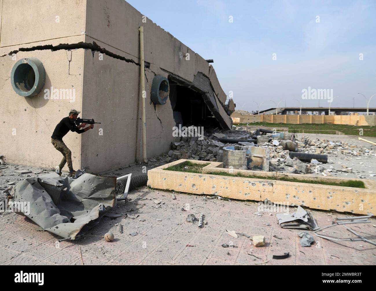 An Iraqi soldier takes a position near an olympic swimming pool ...