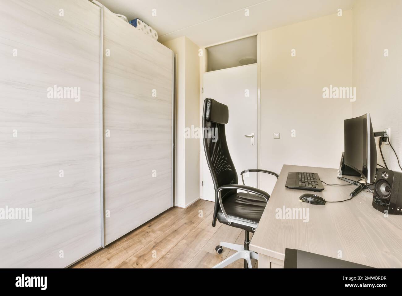 an office space with wood flooring and white walls, including a ...