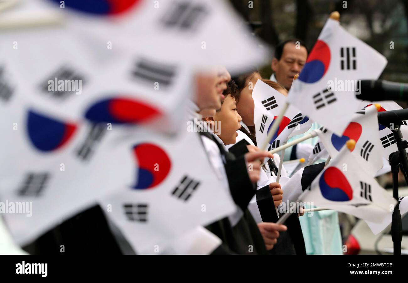 South Koreans wave their national flags during a ceremony to celebrate ...