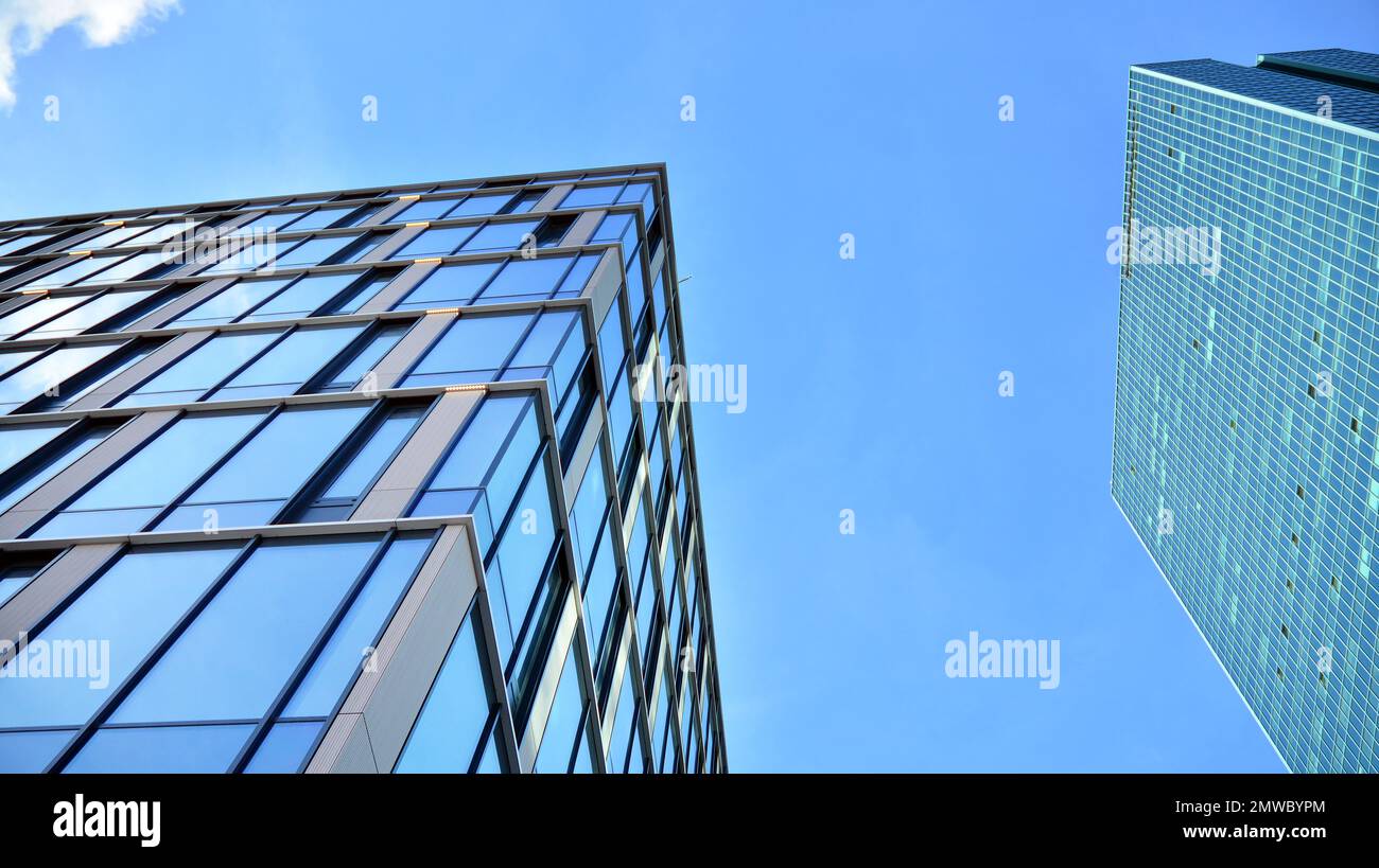Glass facade of the buildings with a blue sky. Skyscrapers in the ...