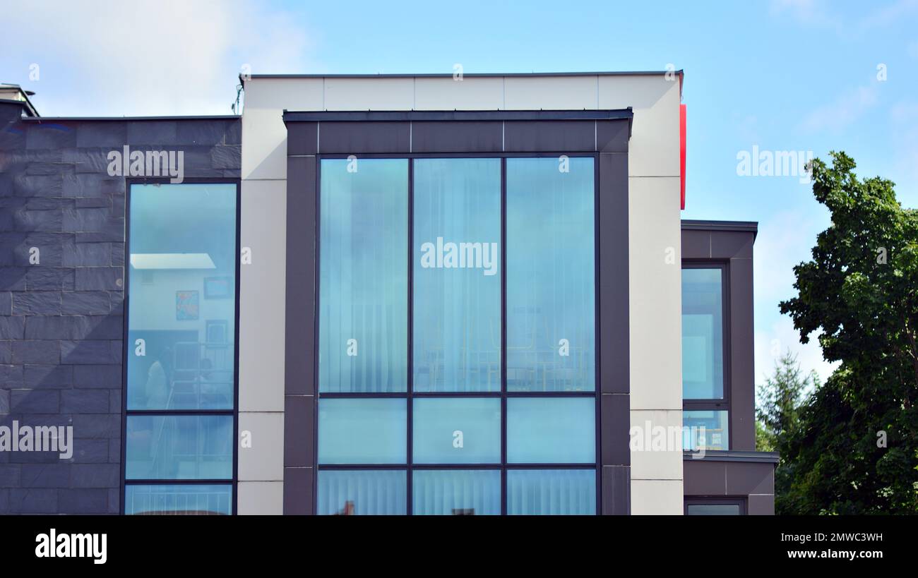 Modern white facade of a residential building with large windows. View ...