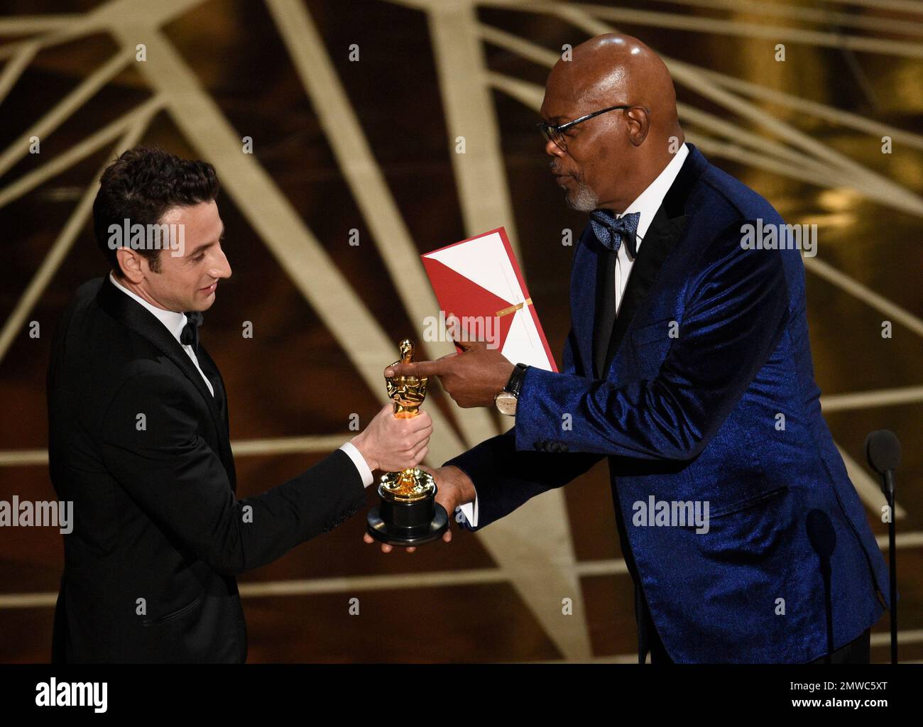 Samuel L. Jackson, right, presents Justin Hurwitz with the award for ...