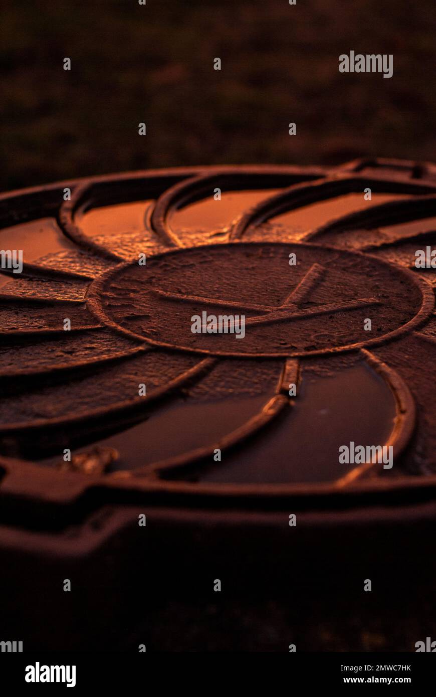 A manhole cover on asphalt at night street, vertical shot Stock Photo ...