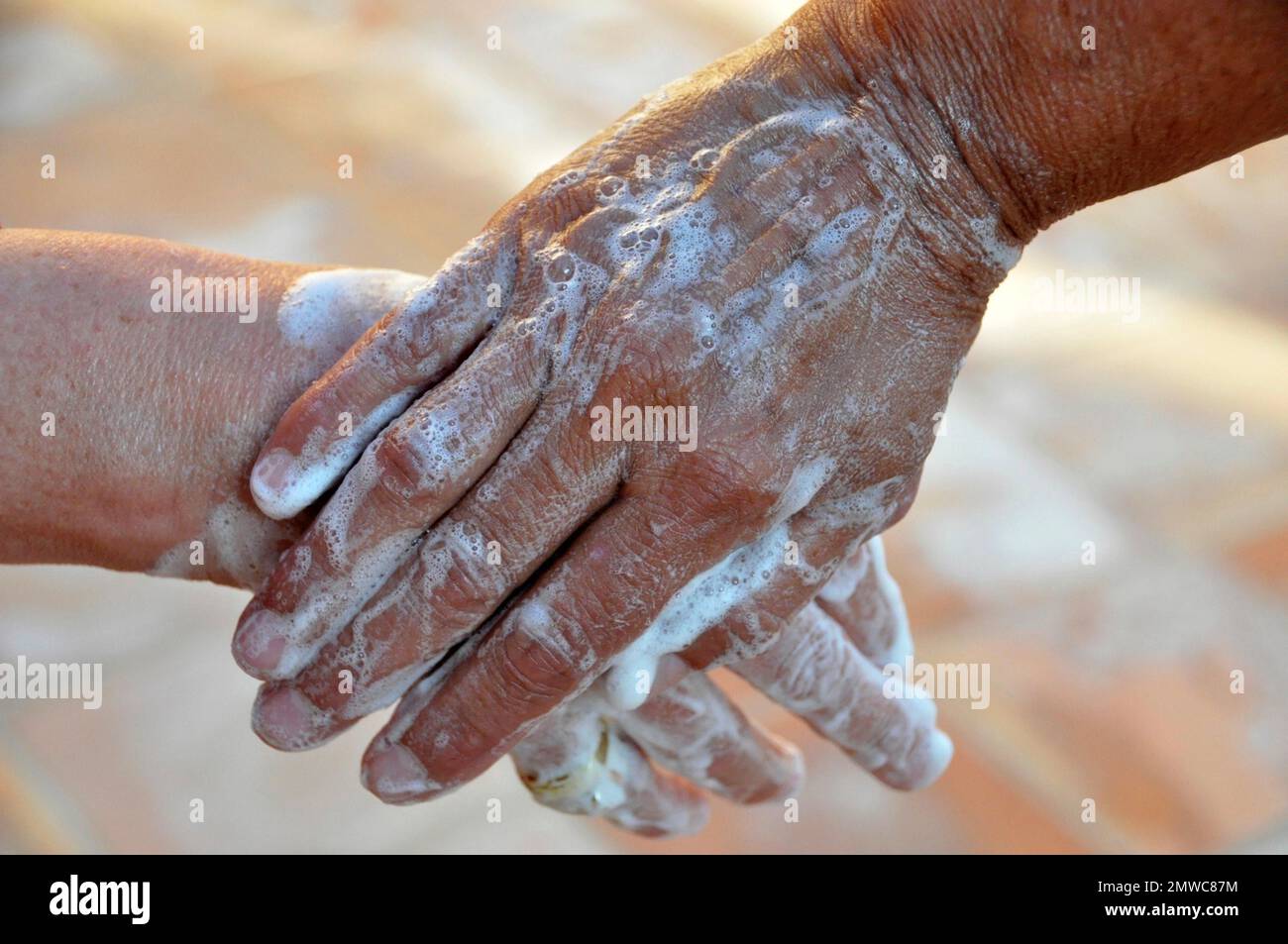 Two soapy hands, one hand washing the other Stock Photo - Alamy