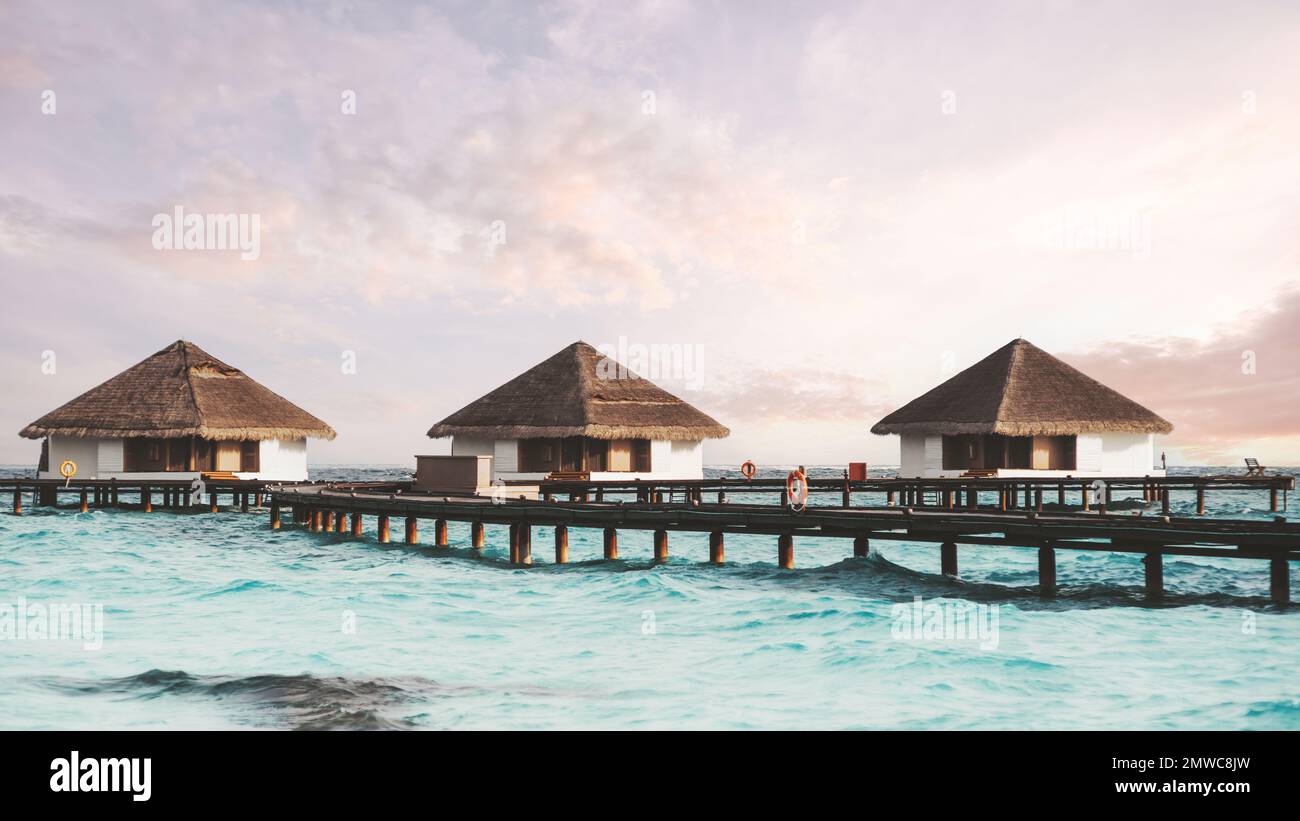 A wide-angle shot of a group of three overwater bungalows with thatched ...