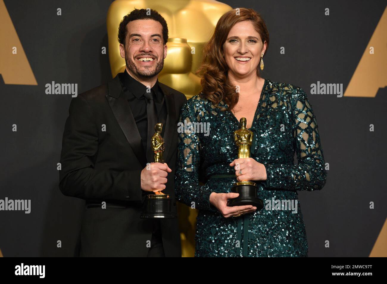 Ezra Edelman, left, and Caroline Waterlow pose in the press room at the ...