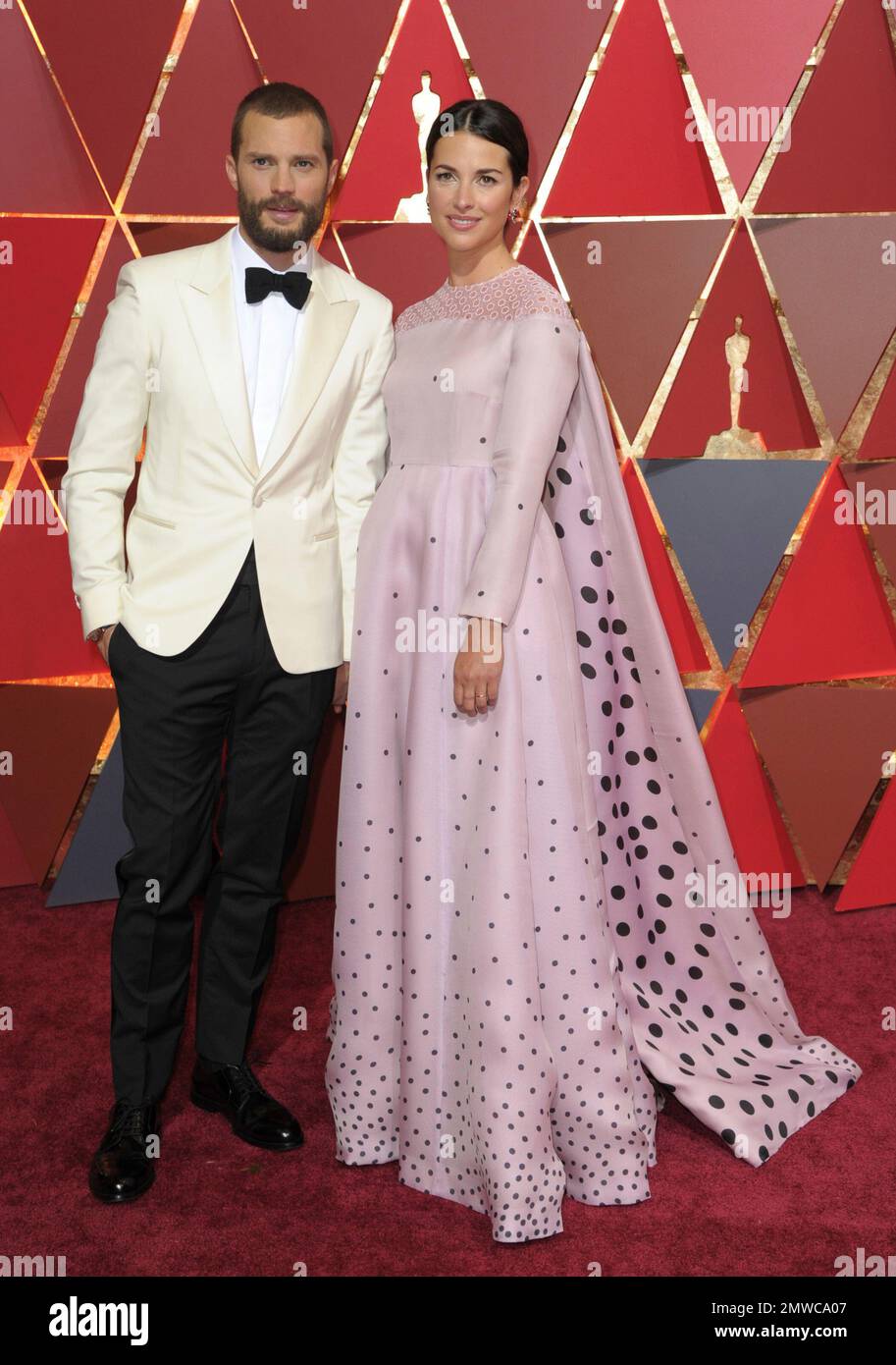 Jamie Dornan, left, and Amelia Warner arrive at the Oscars on Sunday ...