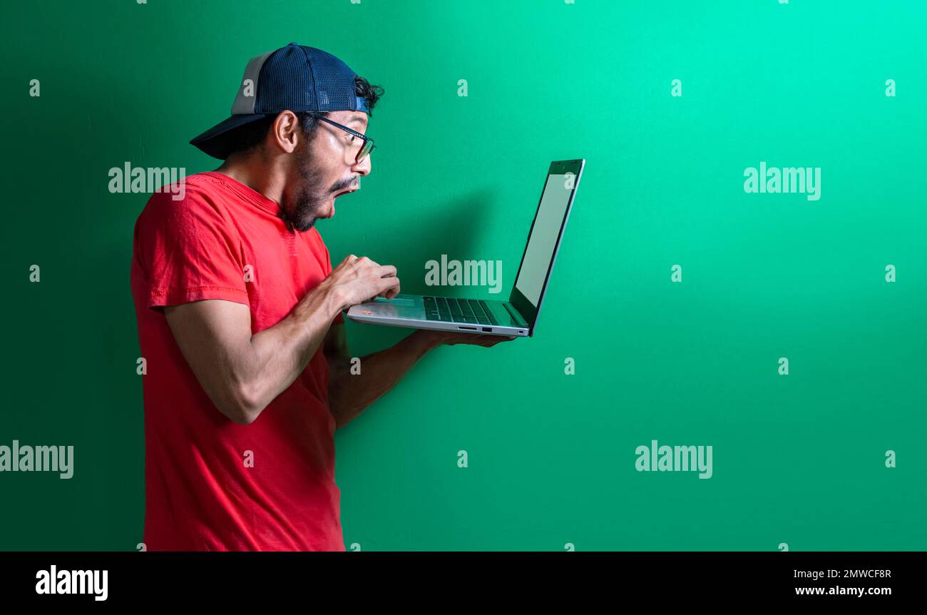 Guy in cap checking his laptop isolated, surprised man checking his ...