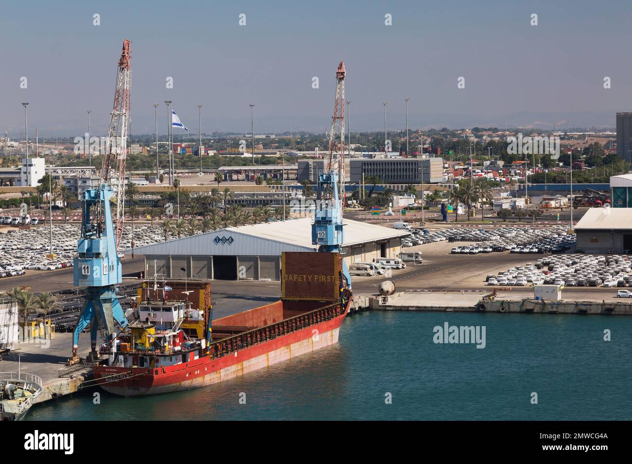 Docked Von Perle cargo ship with four-link loading cranes and parked ...