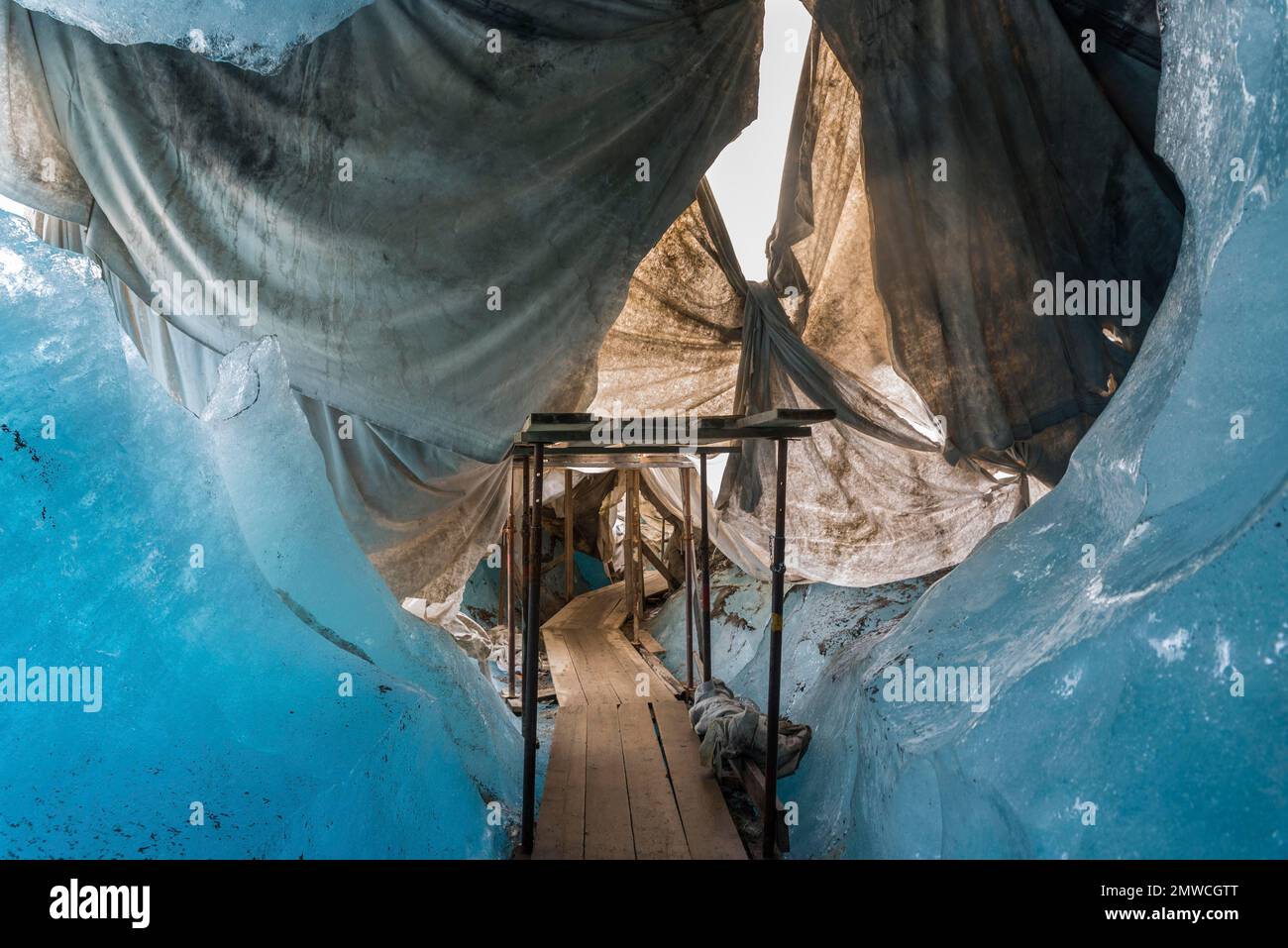 Ice grotto of the Rhone glacier, covered with white tarpaulins to ...