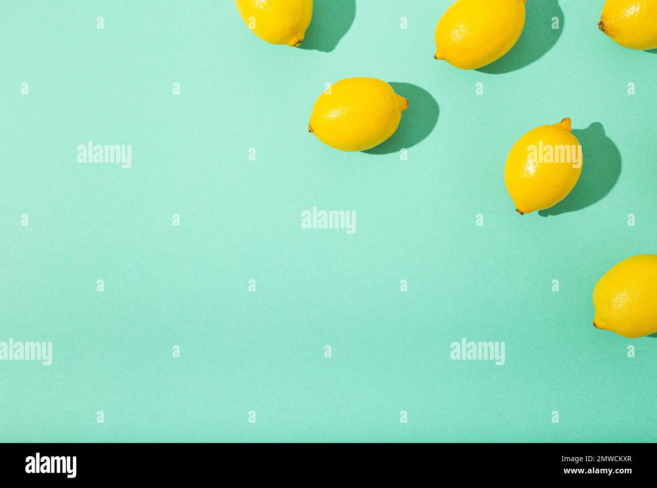Fresh yellow whole lemons on minimal blue background on bright sun ...